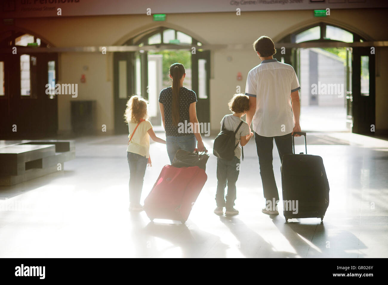 Young family in the waiting room at the station. Dad holds the hand of ...