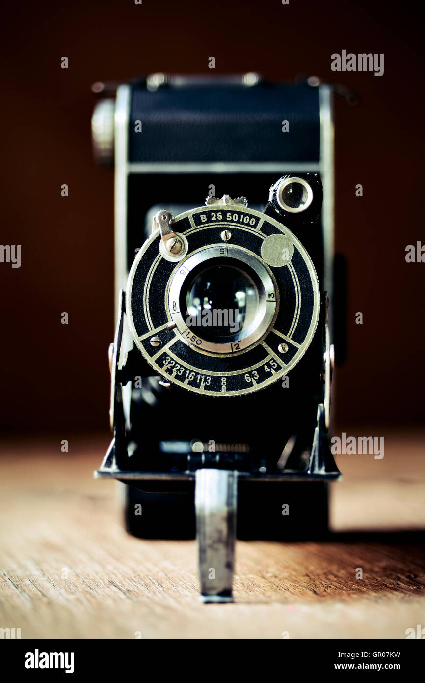 closeup of an old folding camera on a rustic wooden surface Stock Photo ...