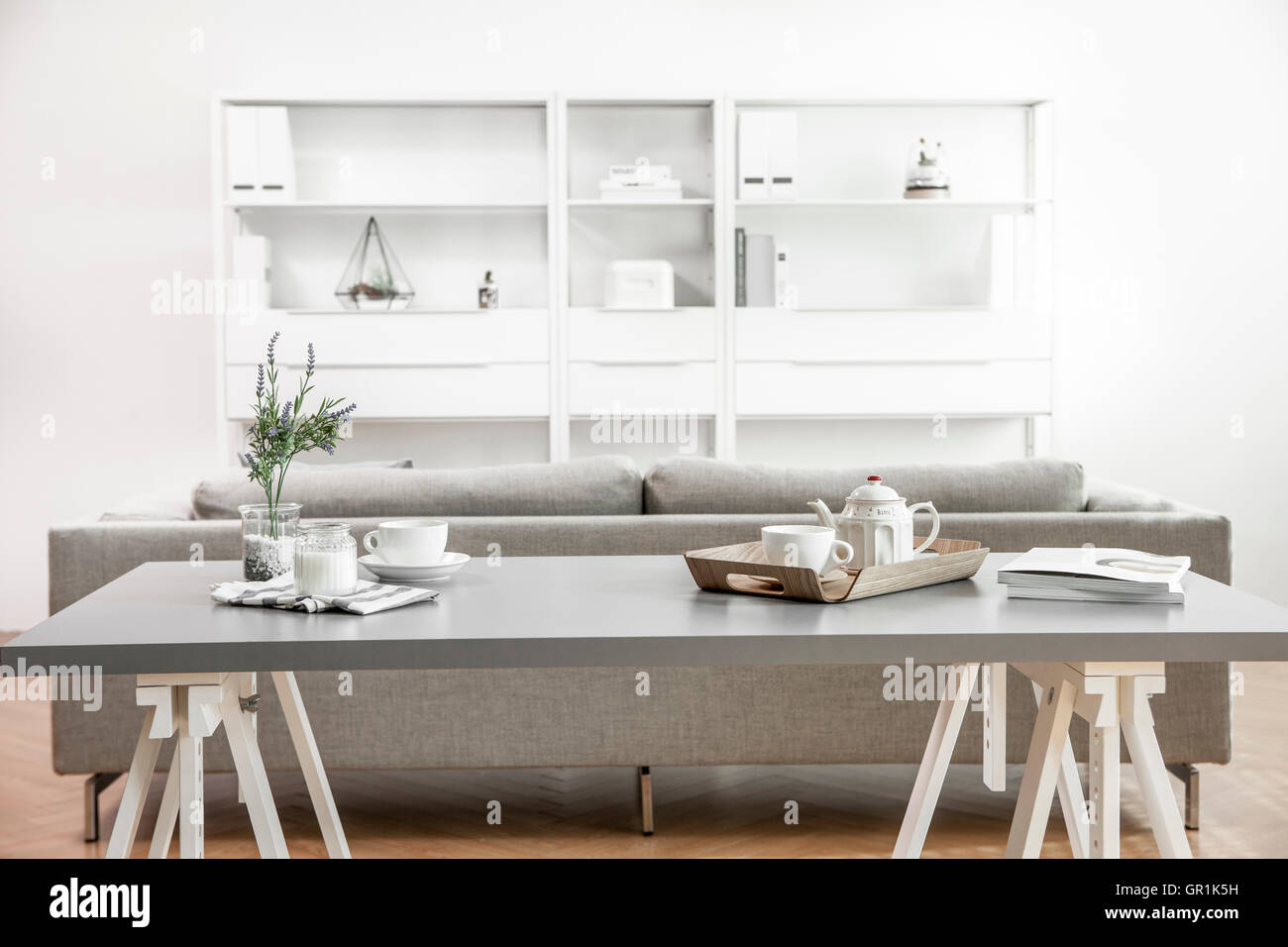 Interior with table, sofa and shelves Stock Photo - Alamy