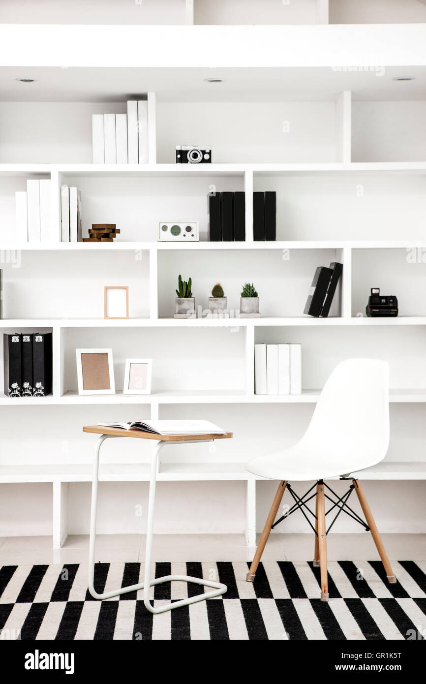 Interior with bookcases, table and chair Stock Photo - Alamy