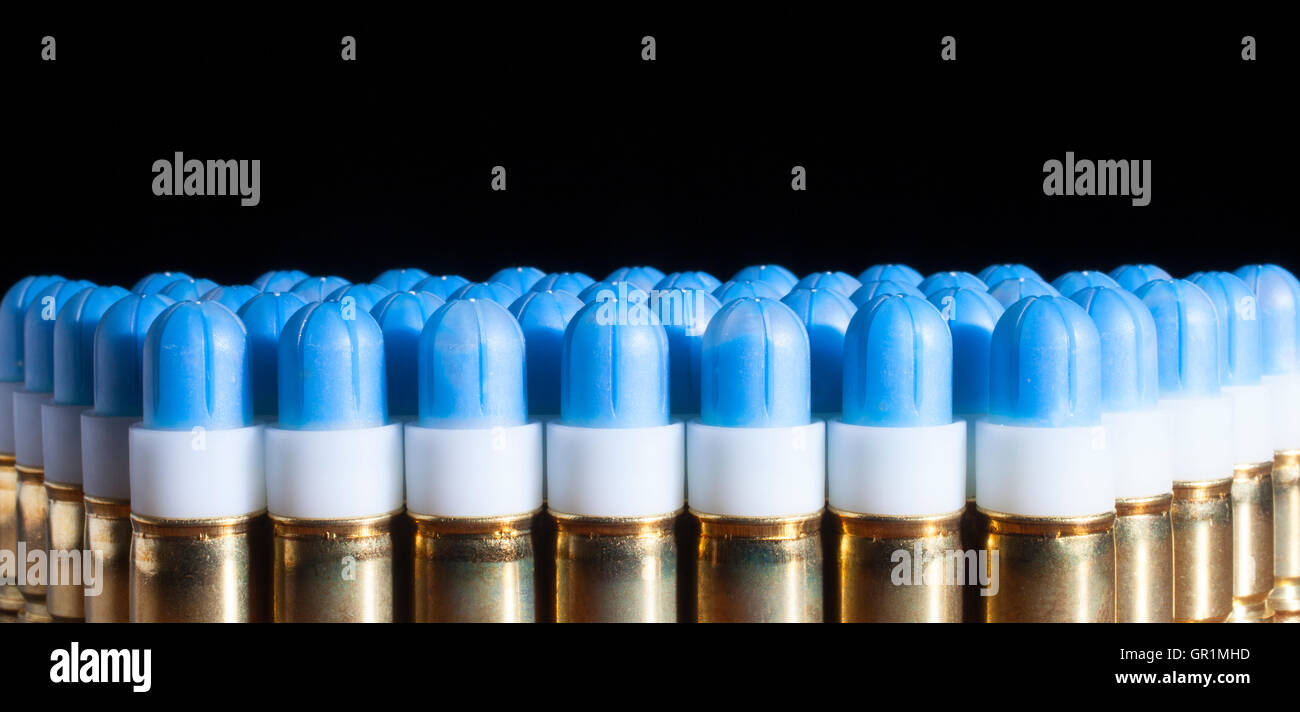Handgun ammunition loaded with blue dye, on black, that marks a target ...