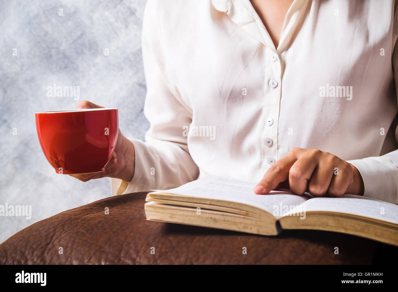 Close up of student hand reading a book with laptop at home. Education ...