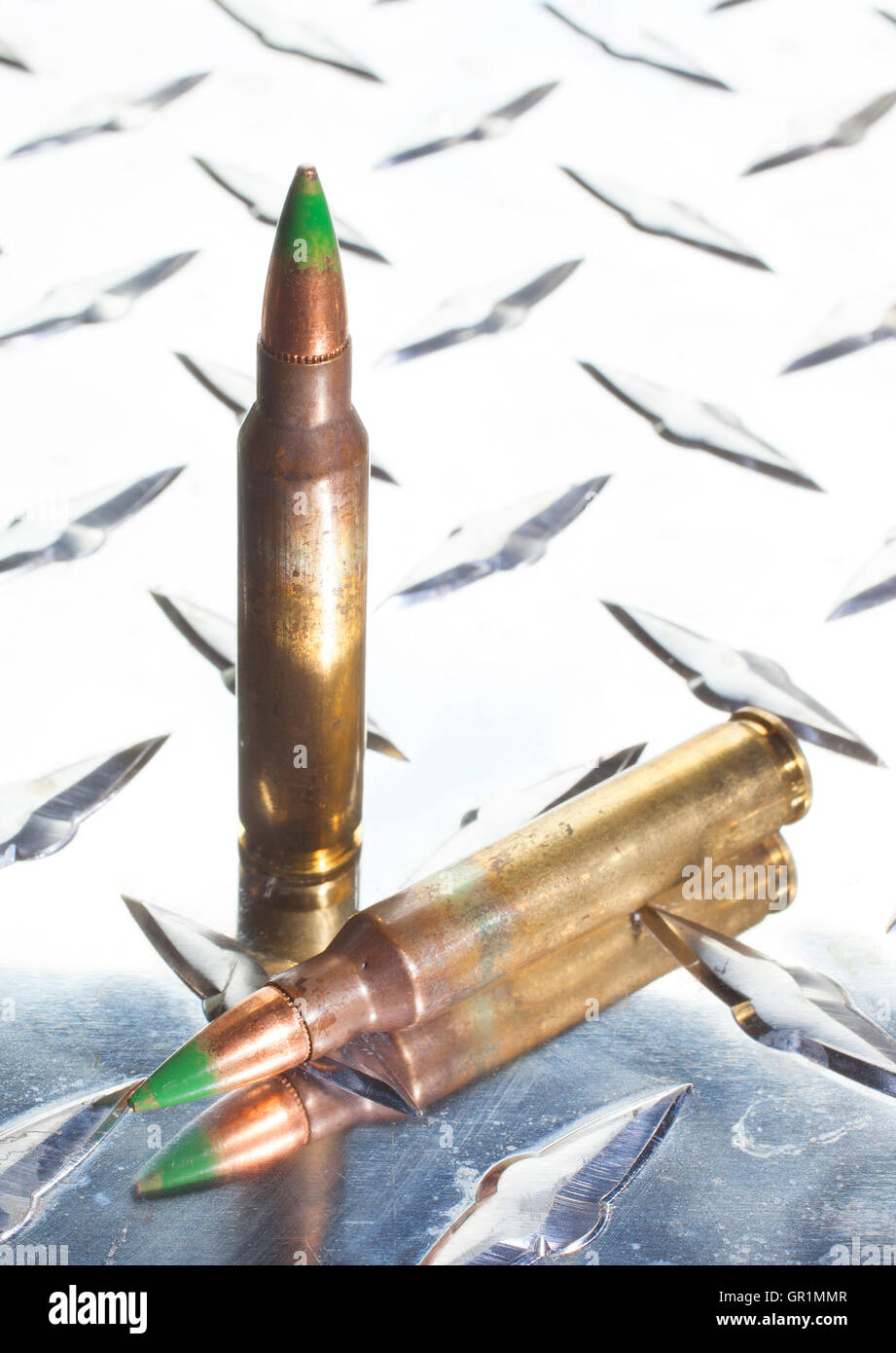 Rifle cartridges with green tipped bullets on an armored metal plate ...