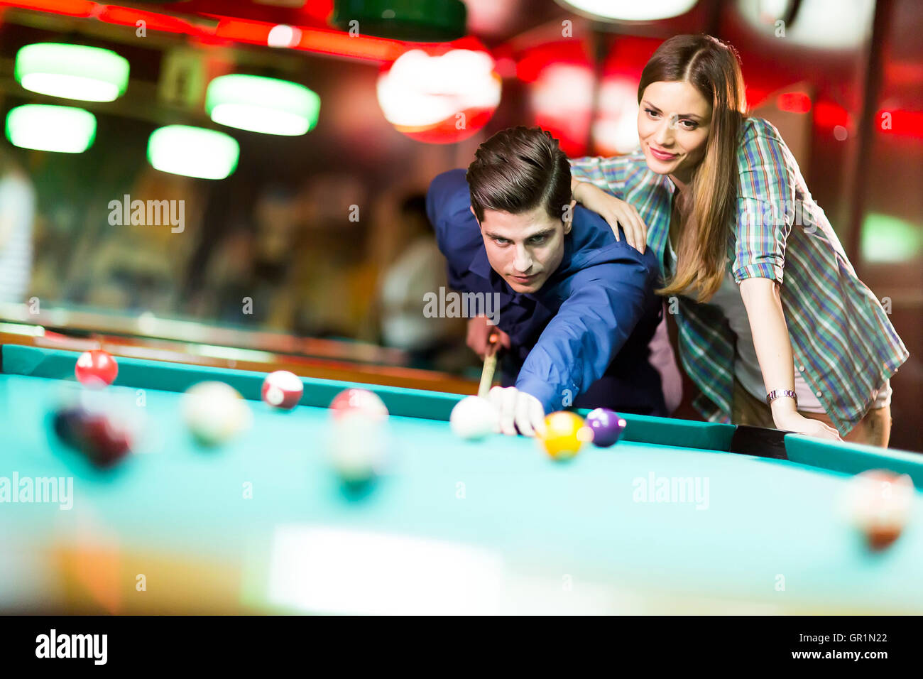 Young couple playing pool in the bar Stock Photo - Alamy