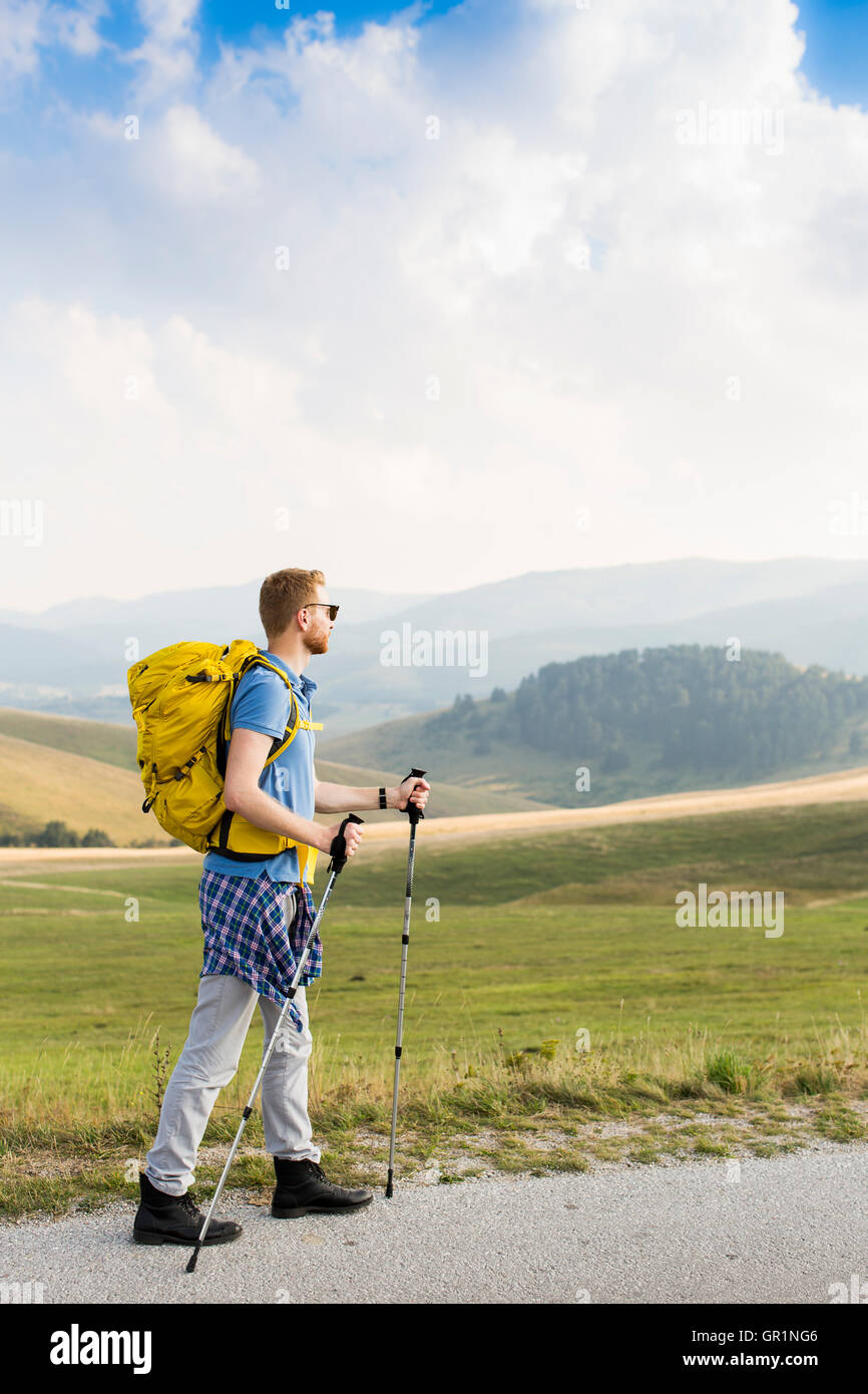 Young man hiking and goes Stock Photo - Alamy