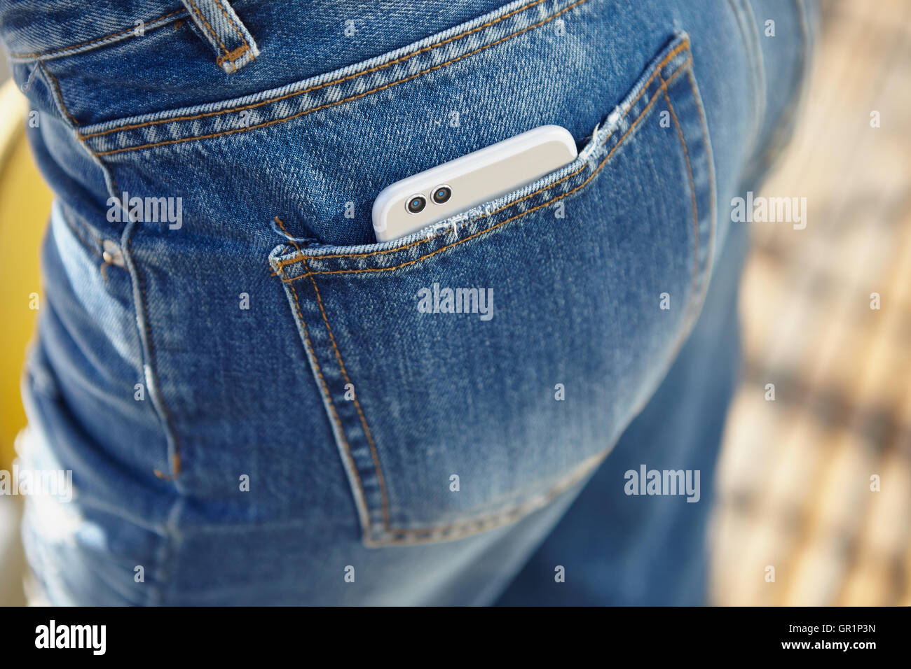 Silver dual lens camera smart phone in rear pocket of blue jeans ...
