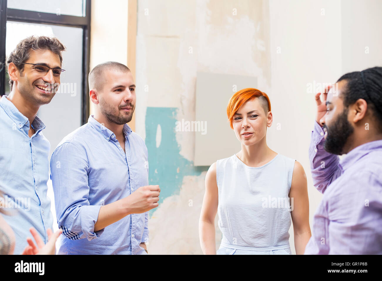 Group of young multiracial freelancers standing and talking in the ...
