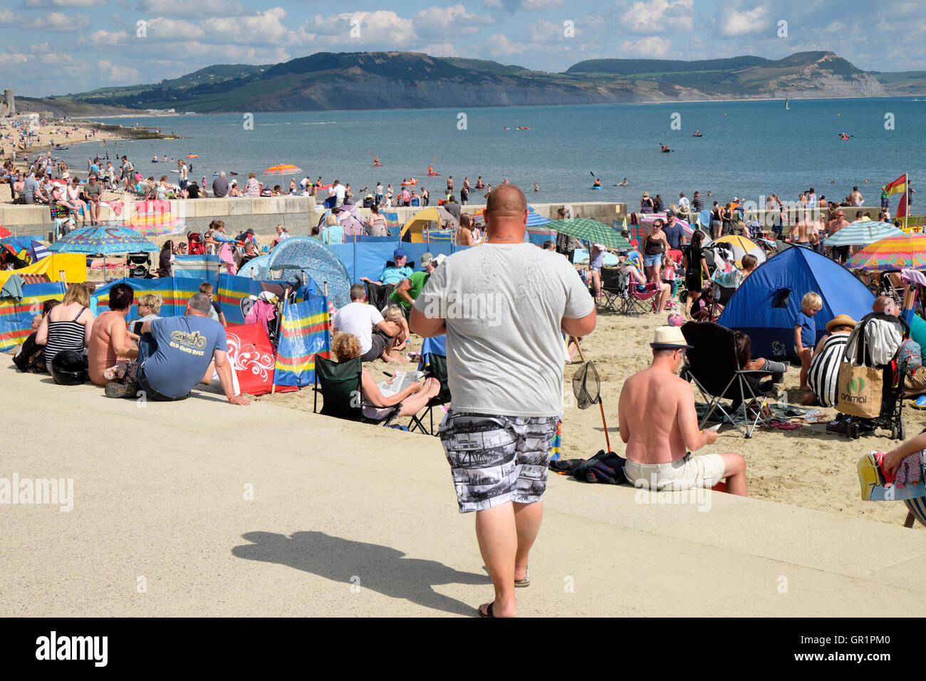 Crowd of people on the seafront beach at Lyme Regis, Dorset, England UK ...