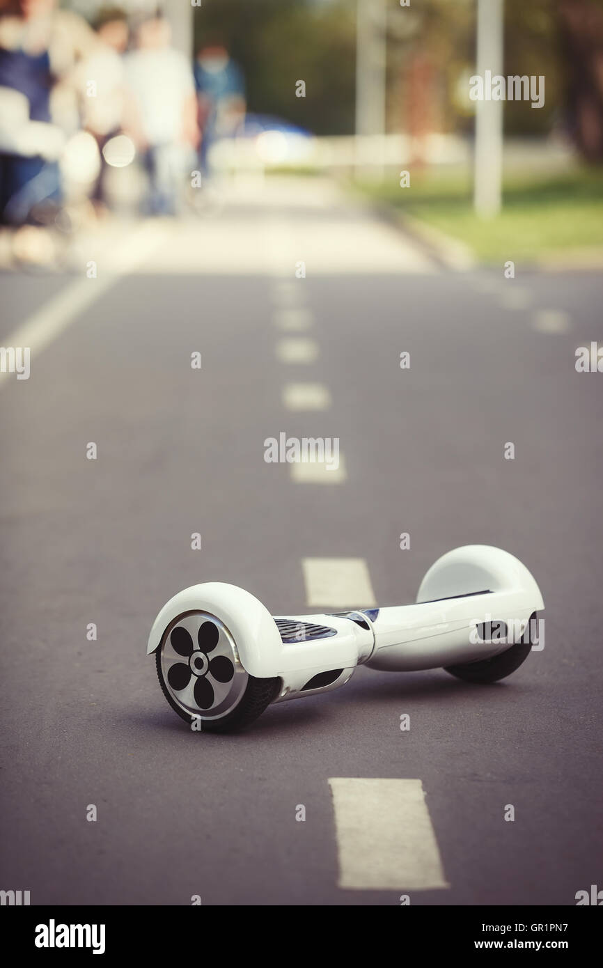 eWhite Electric mini hover board scooter on asphalt road. Eco city ...