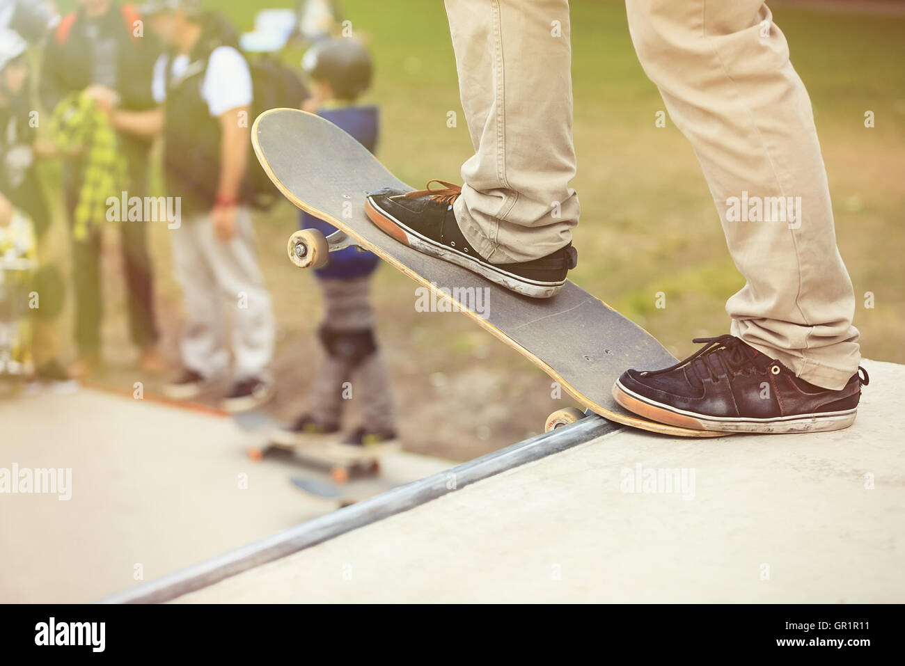 Skateboarder standing on a ramp in skate park ready to ride skate board ...