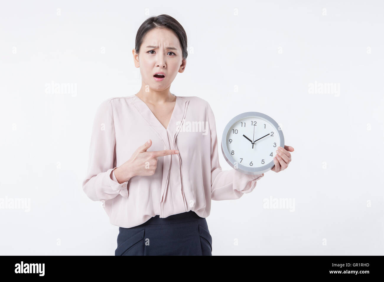 Businesswoman with a clock frowning face Stock Photo - Alamy