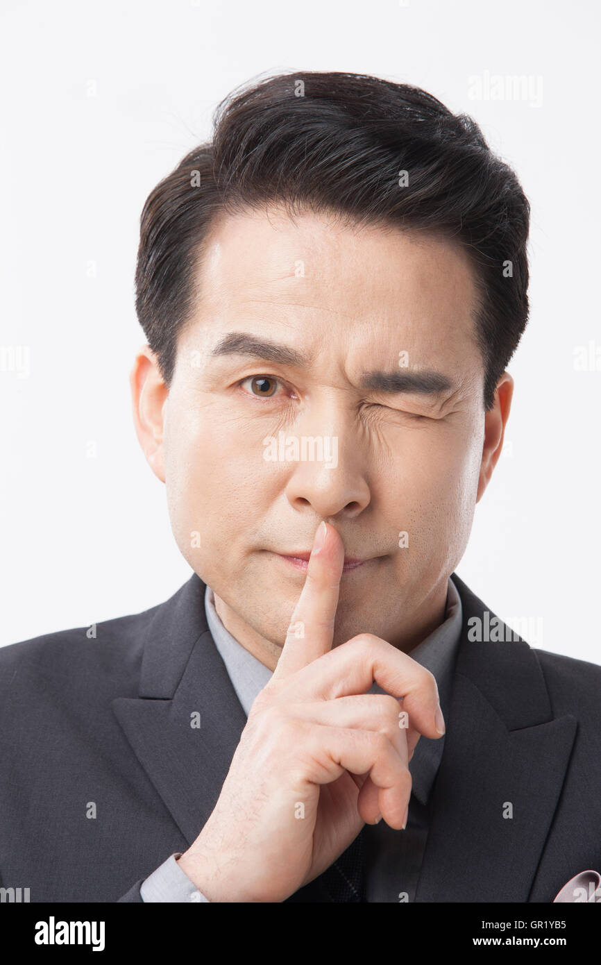 Portrait of middle aged man winking with hush sign Stock Photo - Alamy