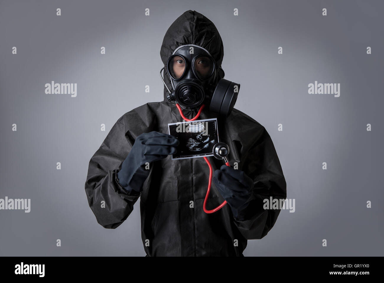 Portrait of man wearing gas mask and protective clothing holding ...
