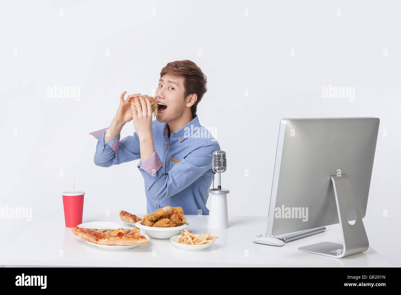 Side view of young smiling man eating during broadcast Stock Photo - Alamy
