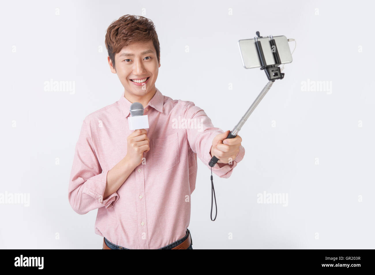 Young smiling man with a.microphone taking selfie Stock Photo - Alamy