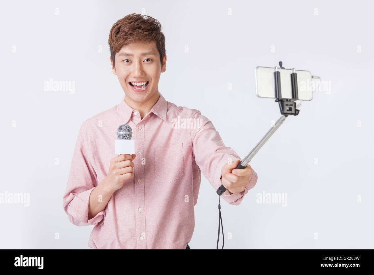 Young smiling man with a microphone taking selfie Stock Photo - Alamy