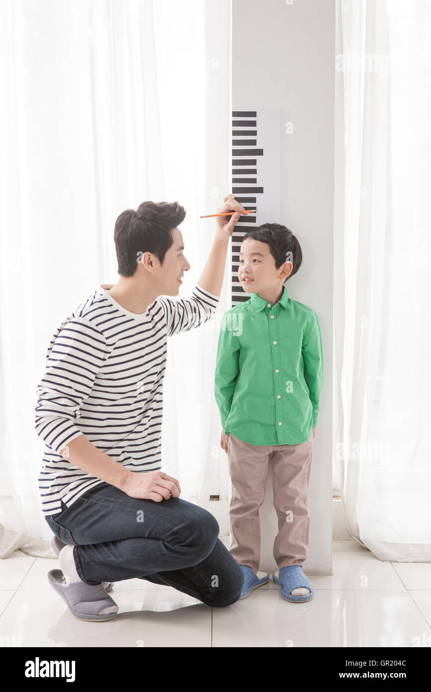 Loving father measuring his son's height Stock Photo - Alamy