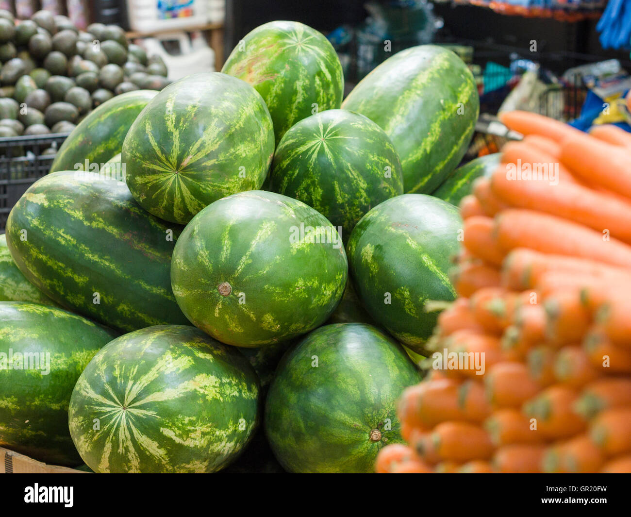 Watermelons and Carrots. Watermelons piled high flanked by a stack of ...