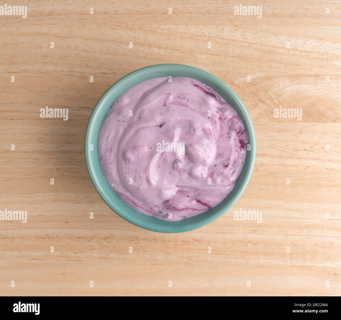 Top view of a bowl with a serving of blueberry gourmet yogurt on a wood ...