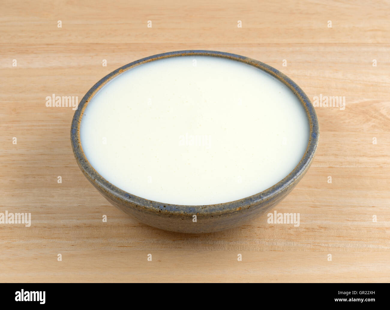 A bowl of buttermilk on a wood table Stock Photo - Alamy
