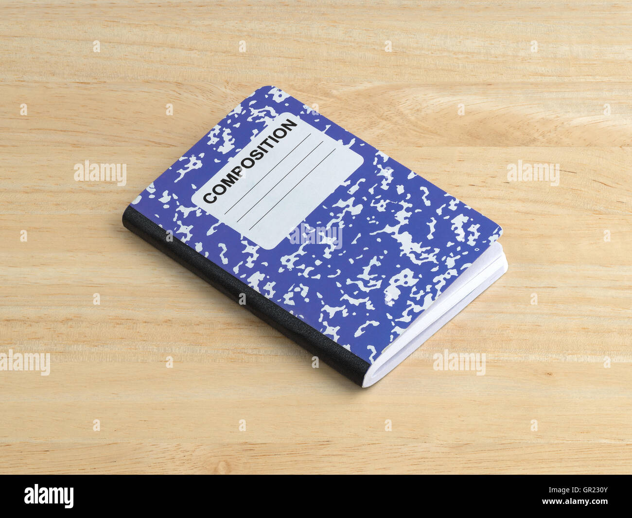 A blue composition notebook on a wood table Stock Photo - Alamy