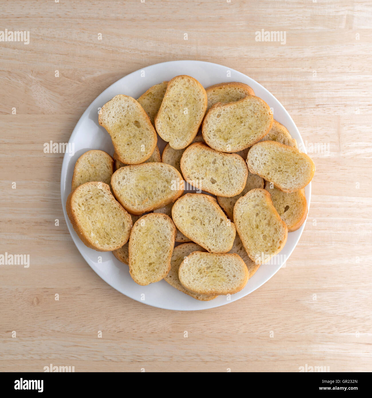 Top view of a plate of crostini that has been dabbed with olive oil on ...