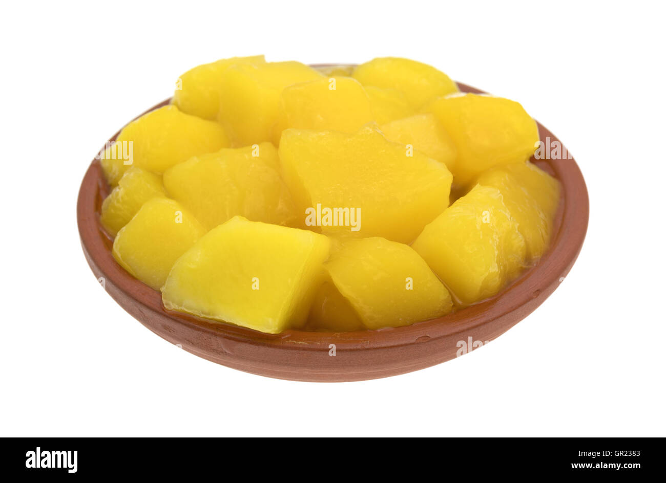 A portion of diced mangoes in light syrup filling a small bowl on a ...