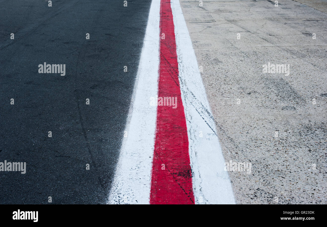 Vertical red and white lines on dark grey asphalt, abstract symbol of ...