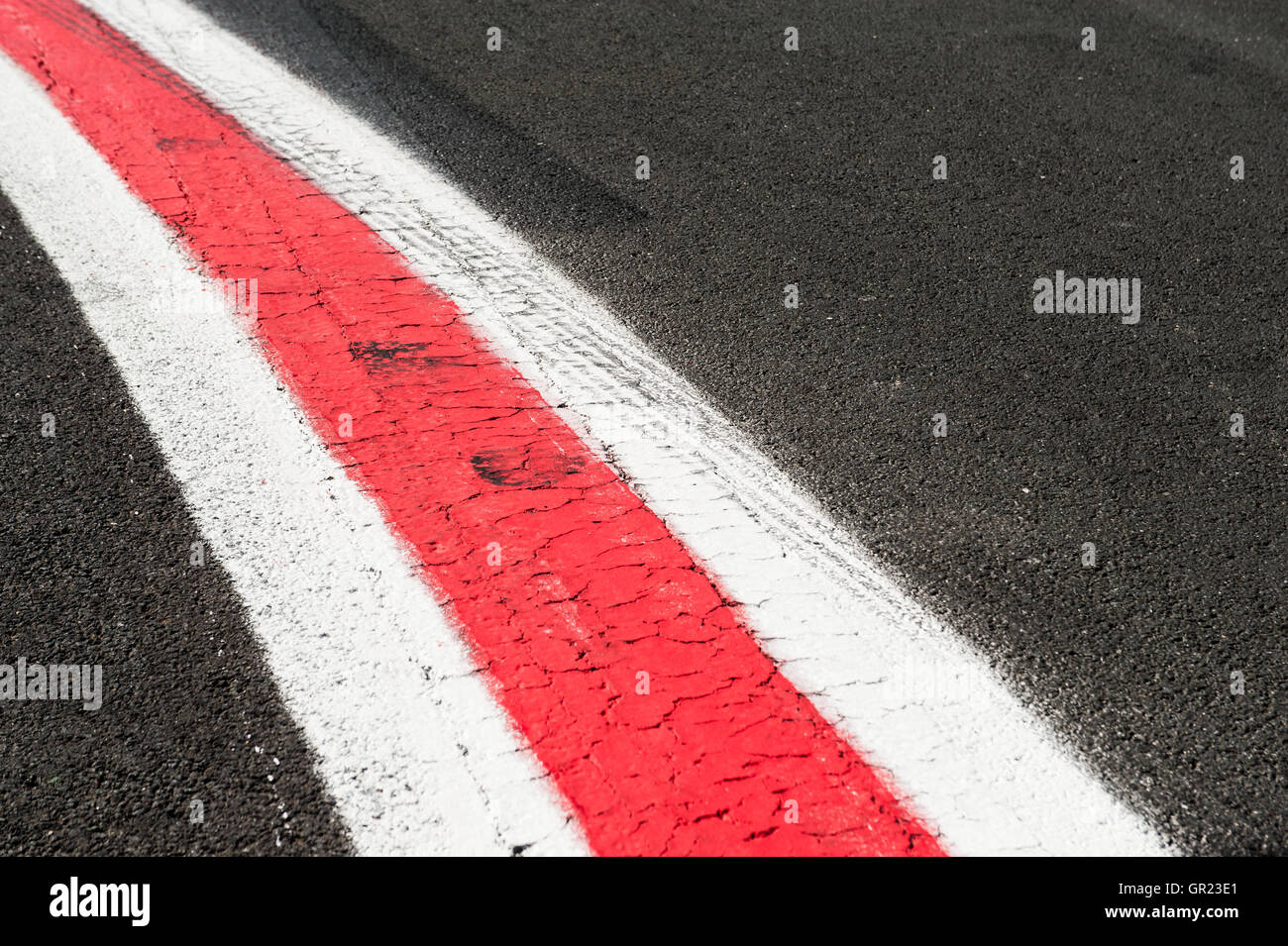 Turning red and white lines on dark grey asphalt, abstract symbol of ...