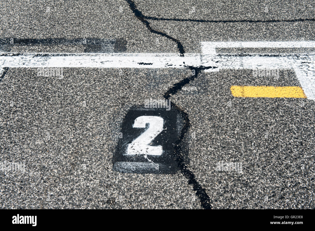 Number two position sign on speedway starting track with yellow line ...