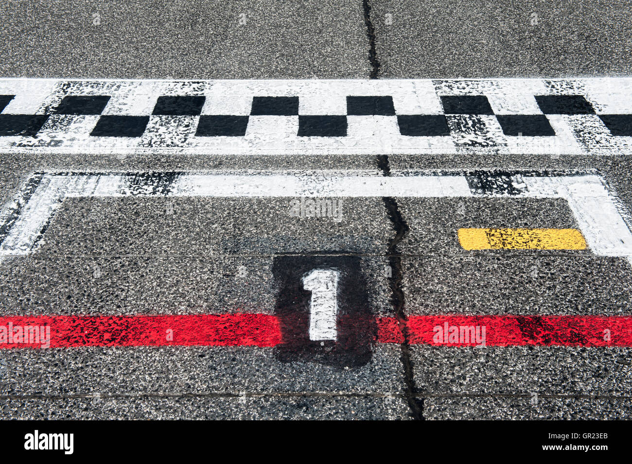 Number one pole position sign on speedway starting track with red line ...