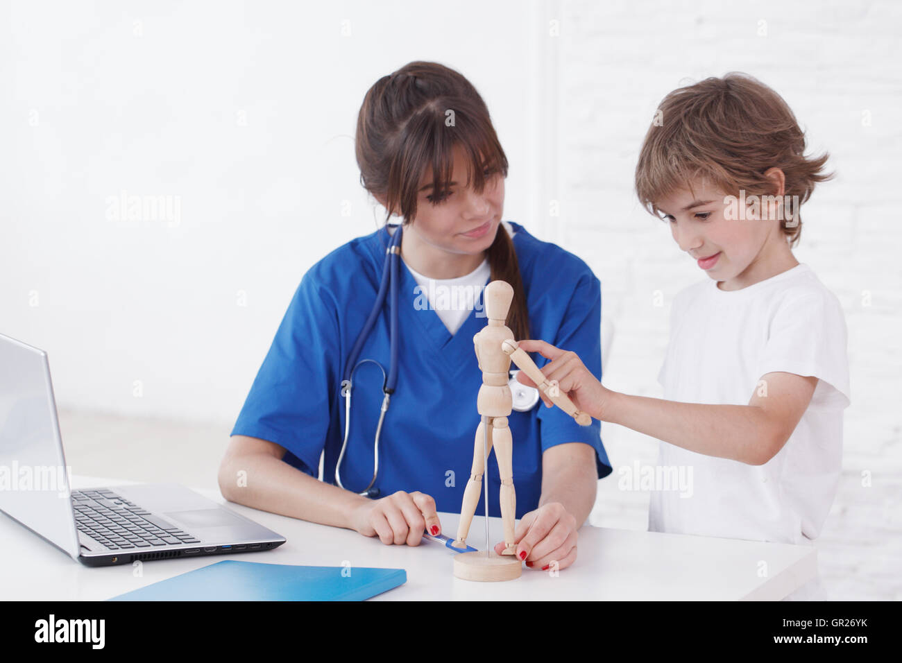 Doctor explain medicine to child using wooden doll Stock Photo - Alamy