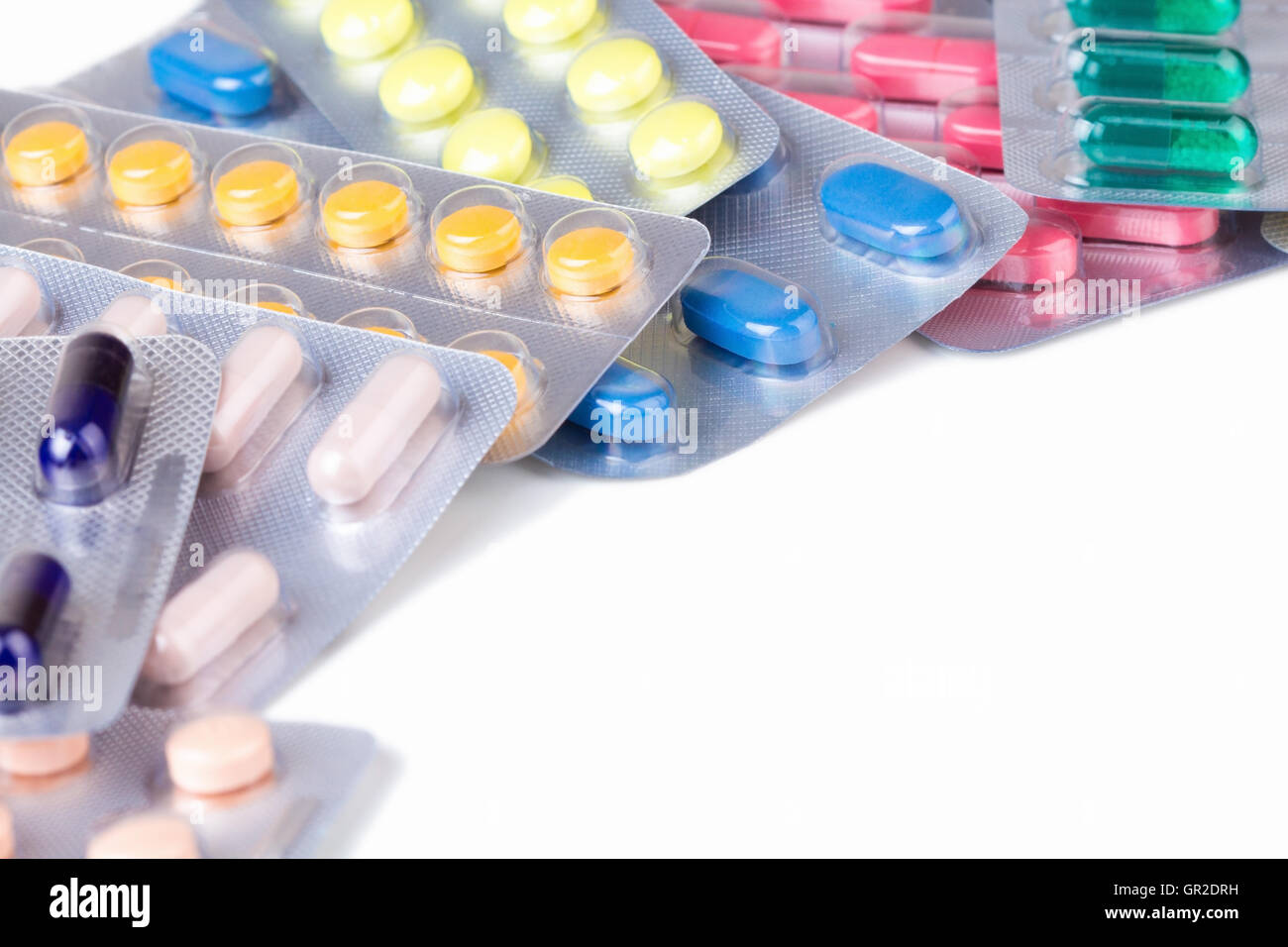 Bunch of pills and capsules in aluminum container on white background ...