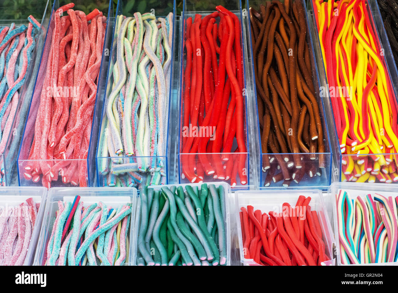 Multicolor tasty licorice candies in plastic containers. Sweet delight ...
