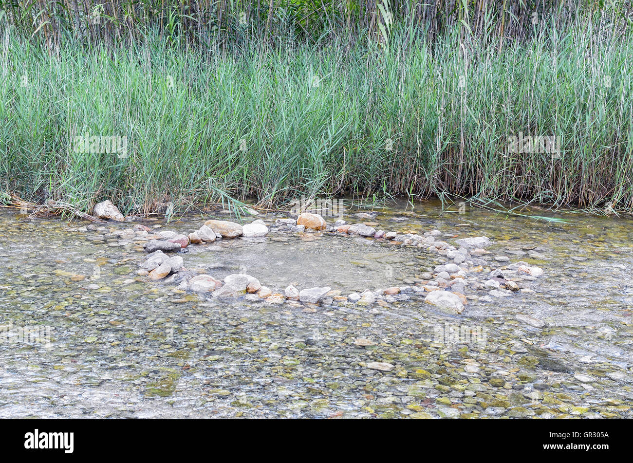 Nature background. Cloudy day. Circle of rocks in the river. Natural ...