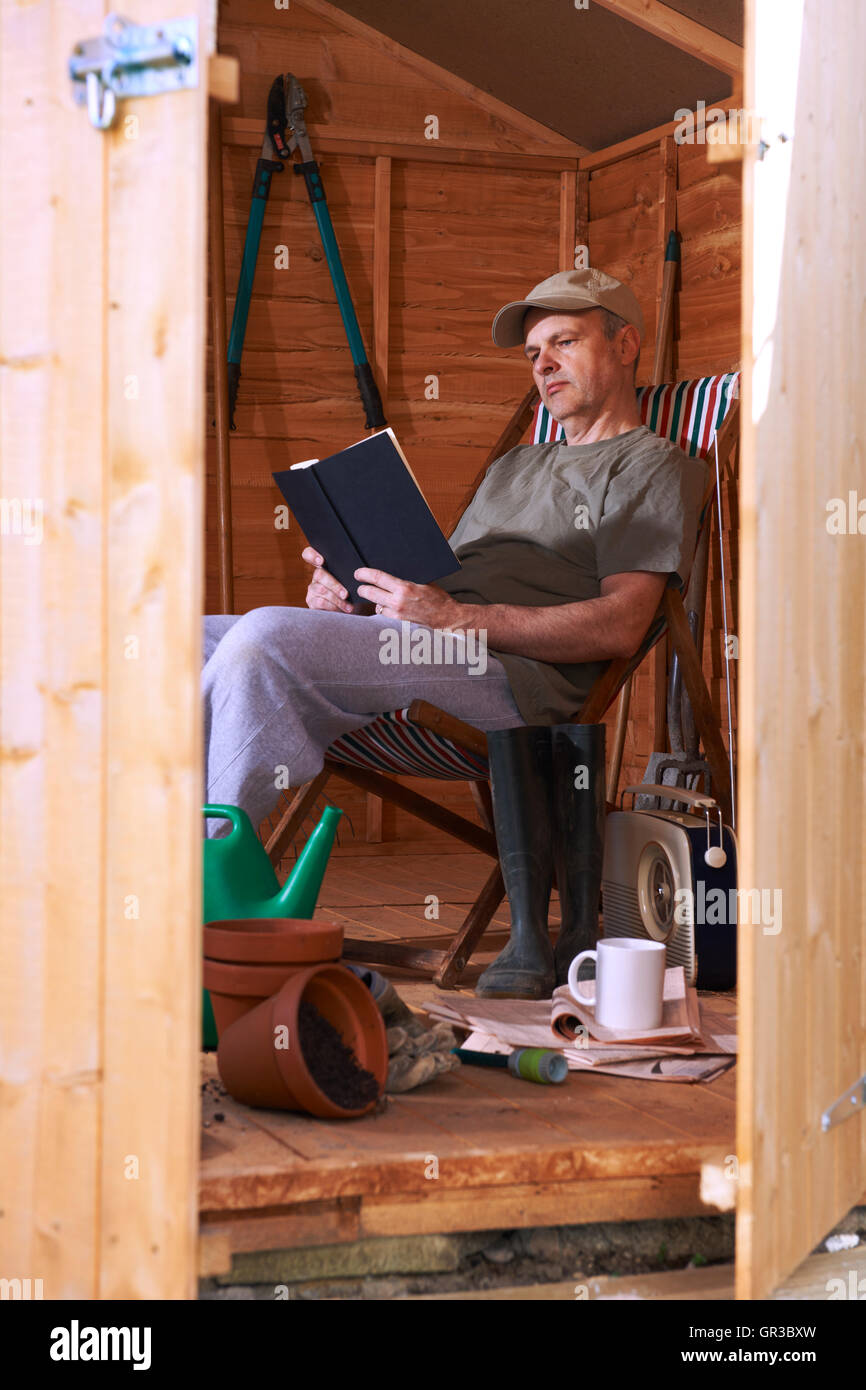 Man reading in garden shed Stock Photo - Alamy