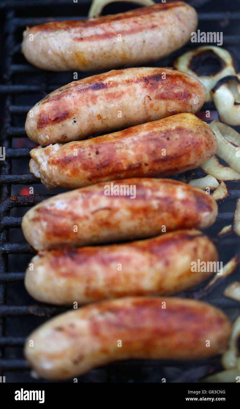 Sausages on grill with onions Stock Photo - Alamy