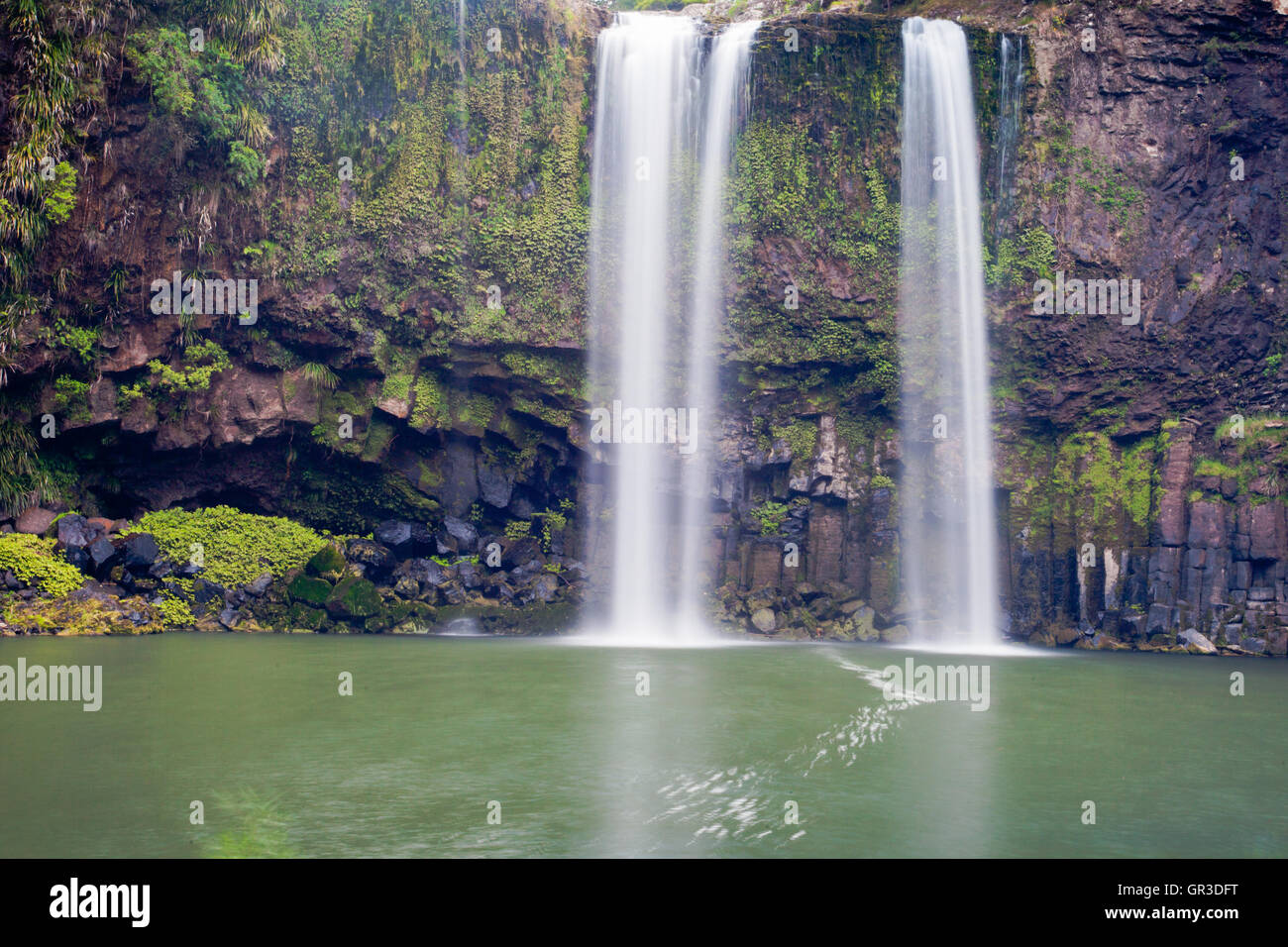 Waterfall cascading over cliff into peaceful pool Stock Photo - Alamy