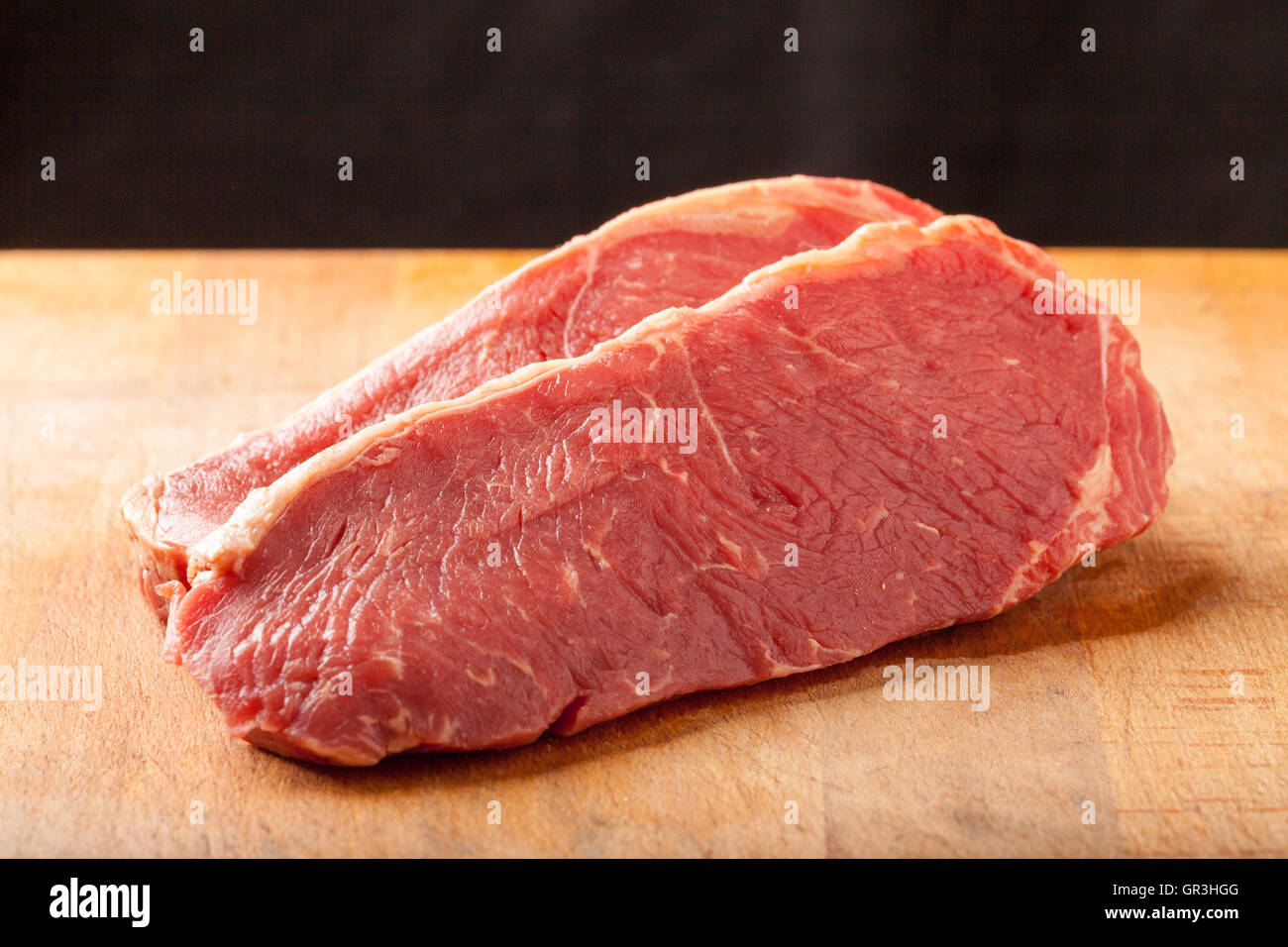 Two Beef Sirloin Steaks on Wooden Board Stock Photo - Alamy