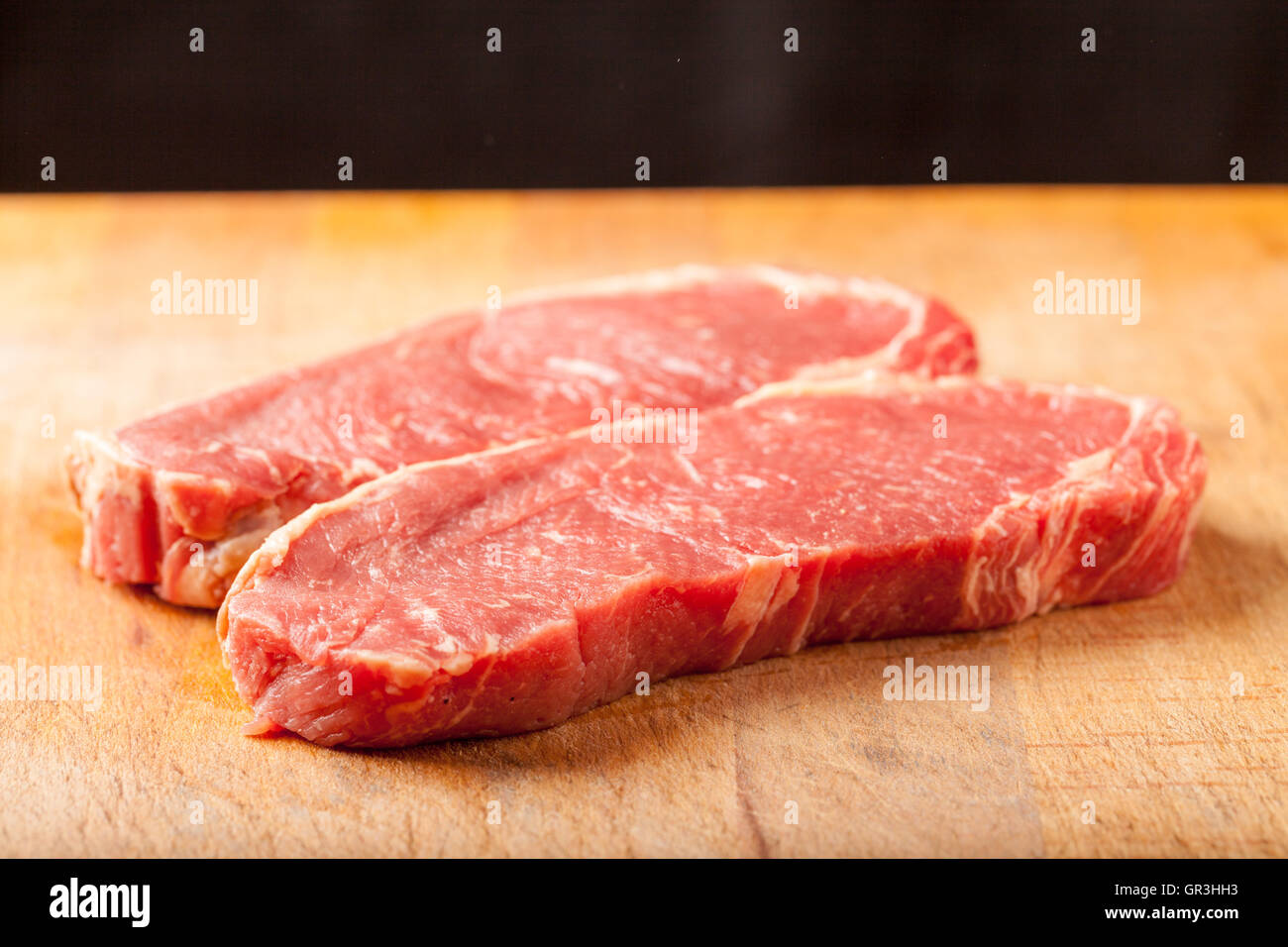 Two Beef Sirloin Steaks on Wooden Board Stock Photo - Alamy