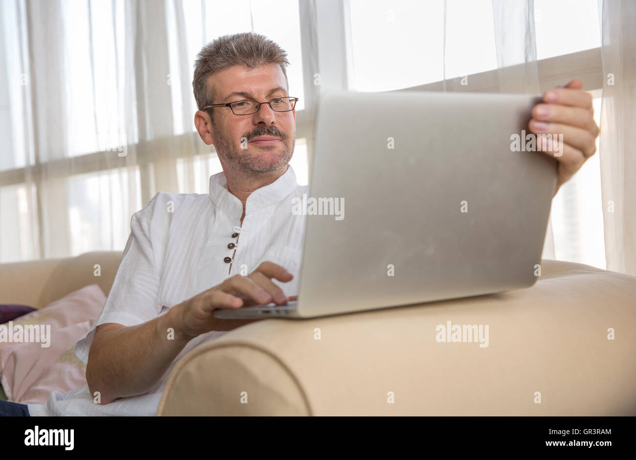 middle aged man working in his computer at hme Stock Photo - Alamy