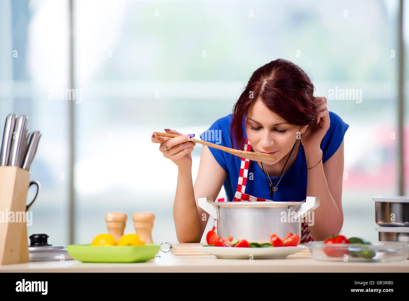 Female cook preparing soup in brightly lit kitchen Stock Photo - Alamy
