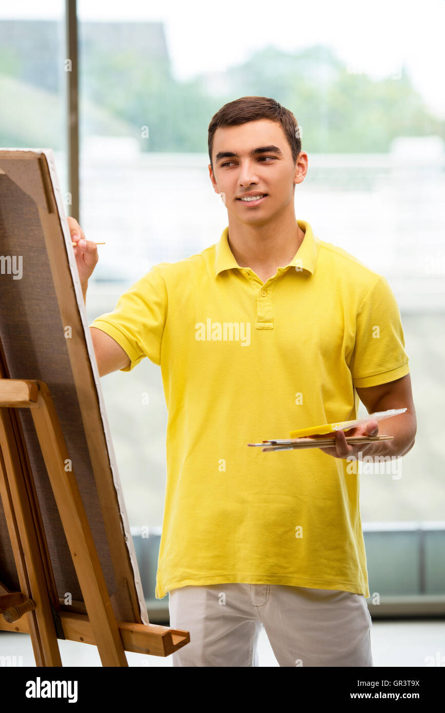 Young male artist drawing pictures in bright studio Stock Photo - Alamy