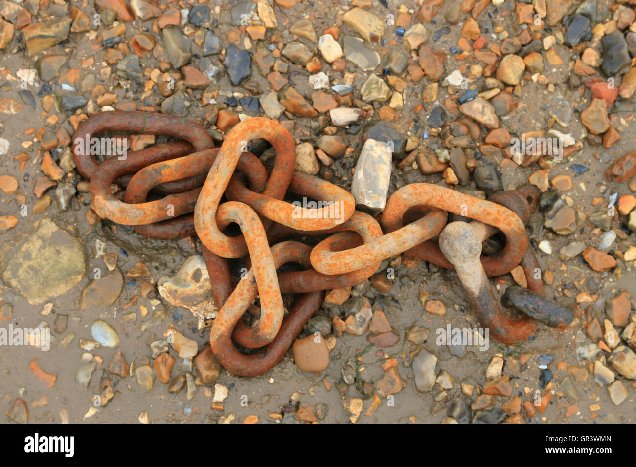 Rusty chain on shingle Stock Photo - Alamy