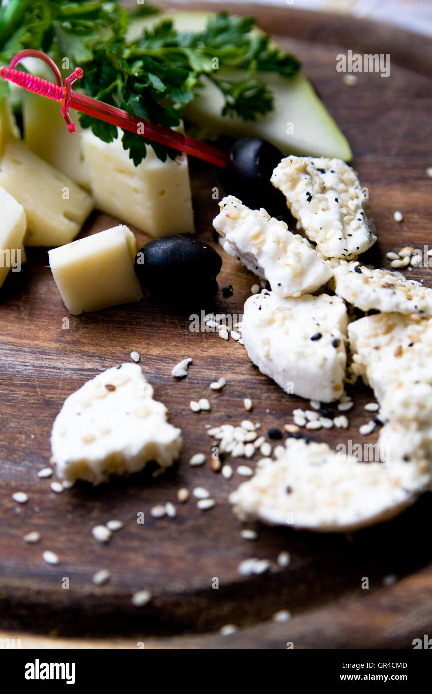 Splitting a solid tasty goat cheese with sesame seeds and herbs Stock ...