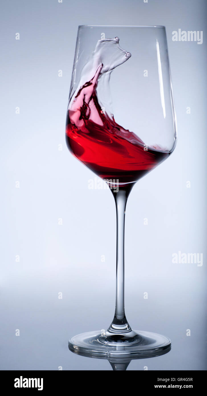 Red wine splashing in the elegant glass. Clipping path Stock Photo - Alamy