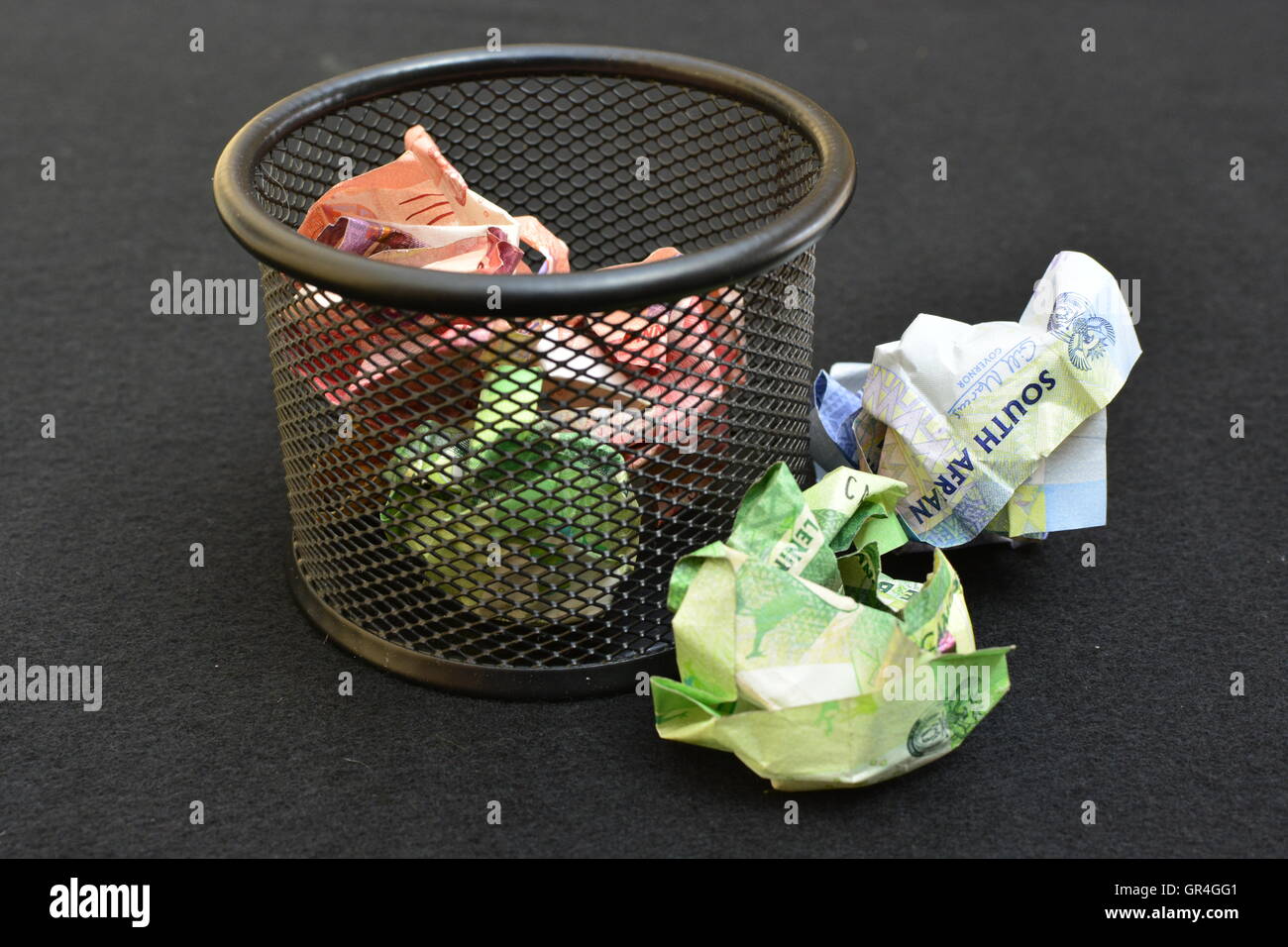 Wasting money concept. Throwing money away. Money in wastepaper basket ...