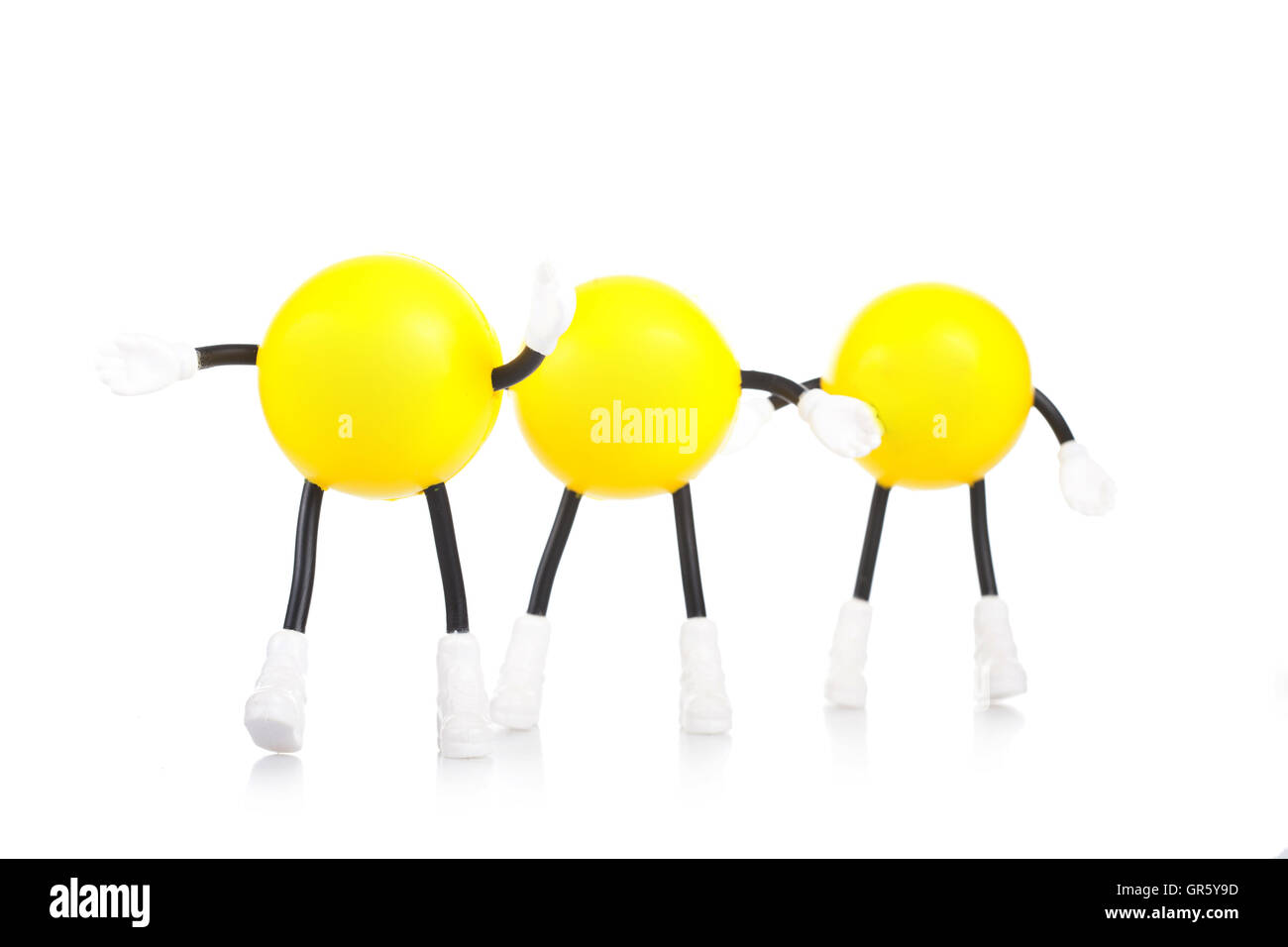 Three toy little men on a white background Stock Photo - Alamy