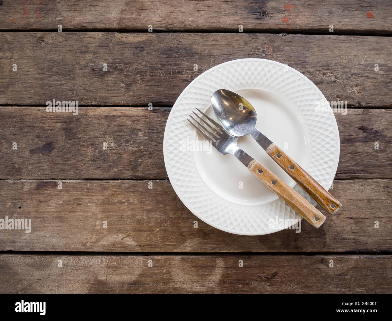 Empty dish with spoon and fork on wooden table. Top view Stock Photo ...