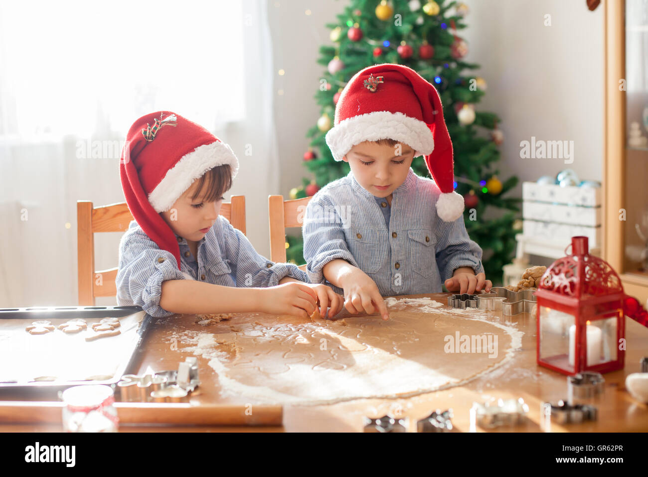 Two cute boys with santa hat, preparing cookies at home, Christmas tree ...